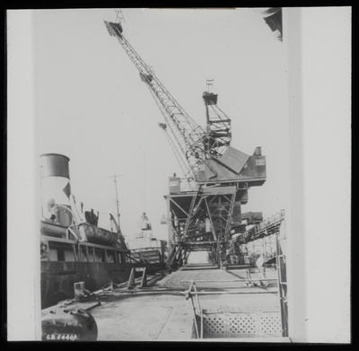 Lantern slide: Image of a crane with luffing system alongside the wharf ...