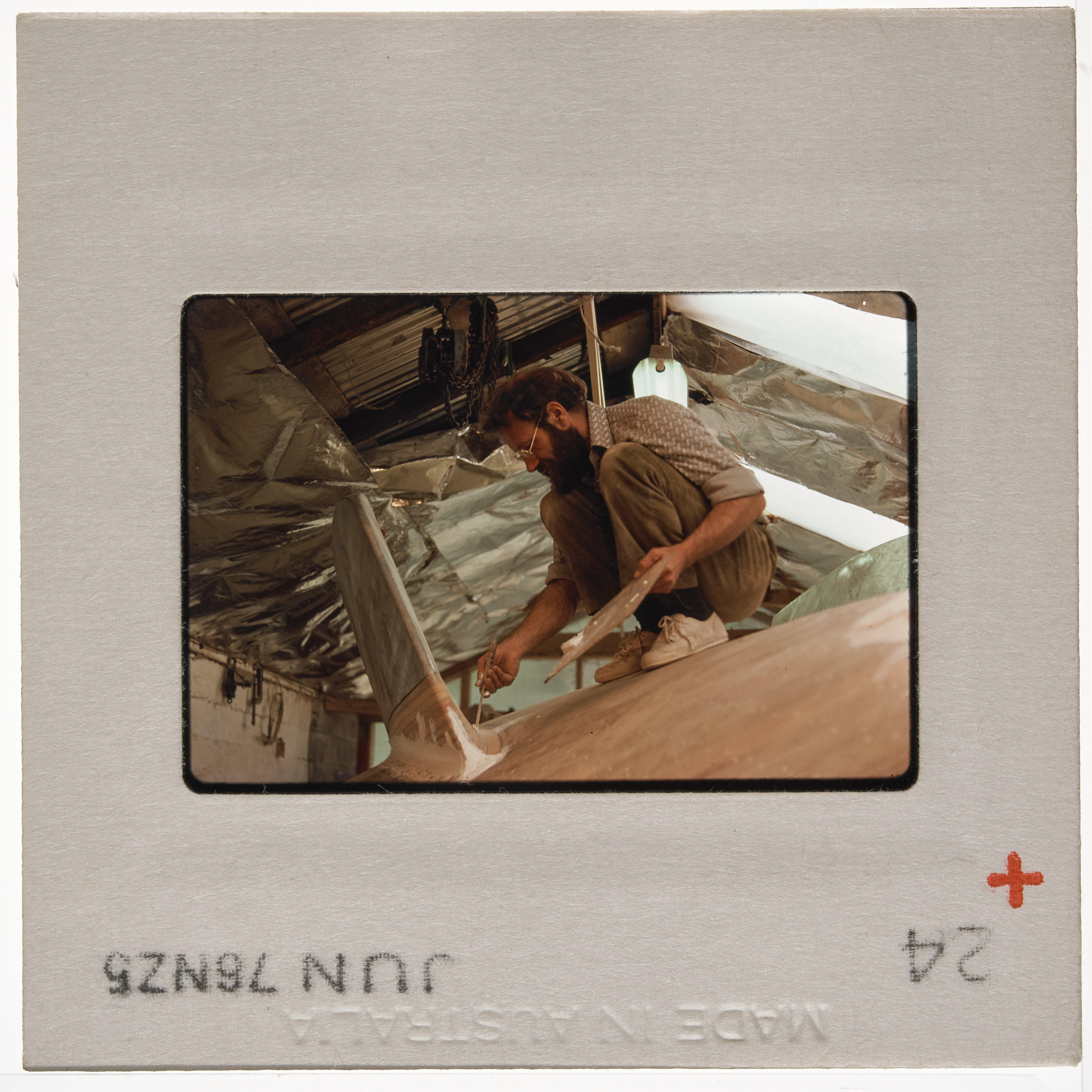 Slide: Person working on a keel of a yacht - New Zealand Maritime Museum