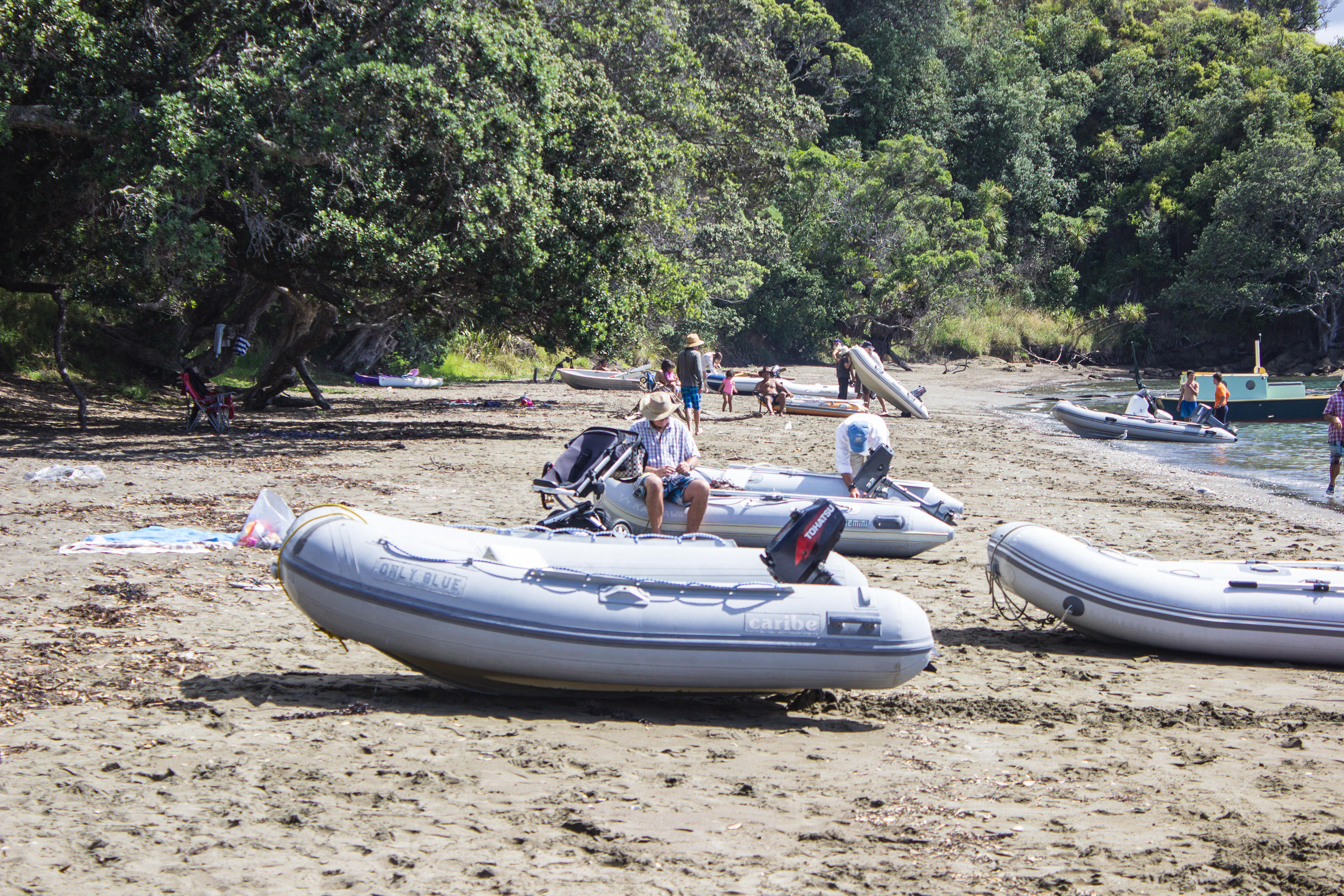 Photograph: People and dinghies on beach, Sullivan's Bay, Mahurangi ...