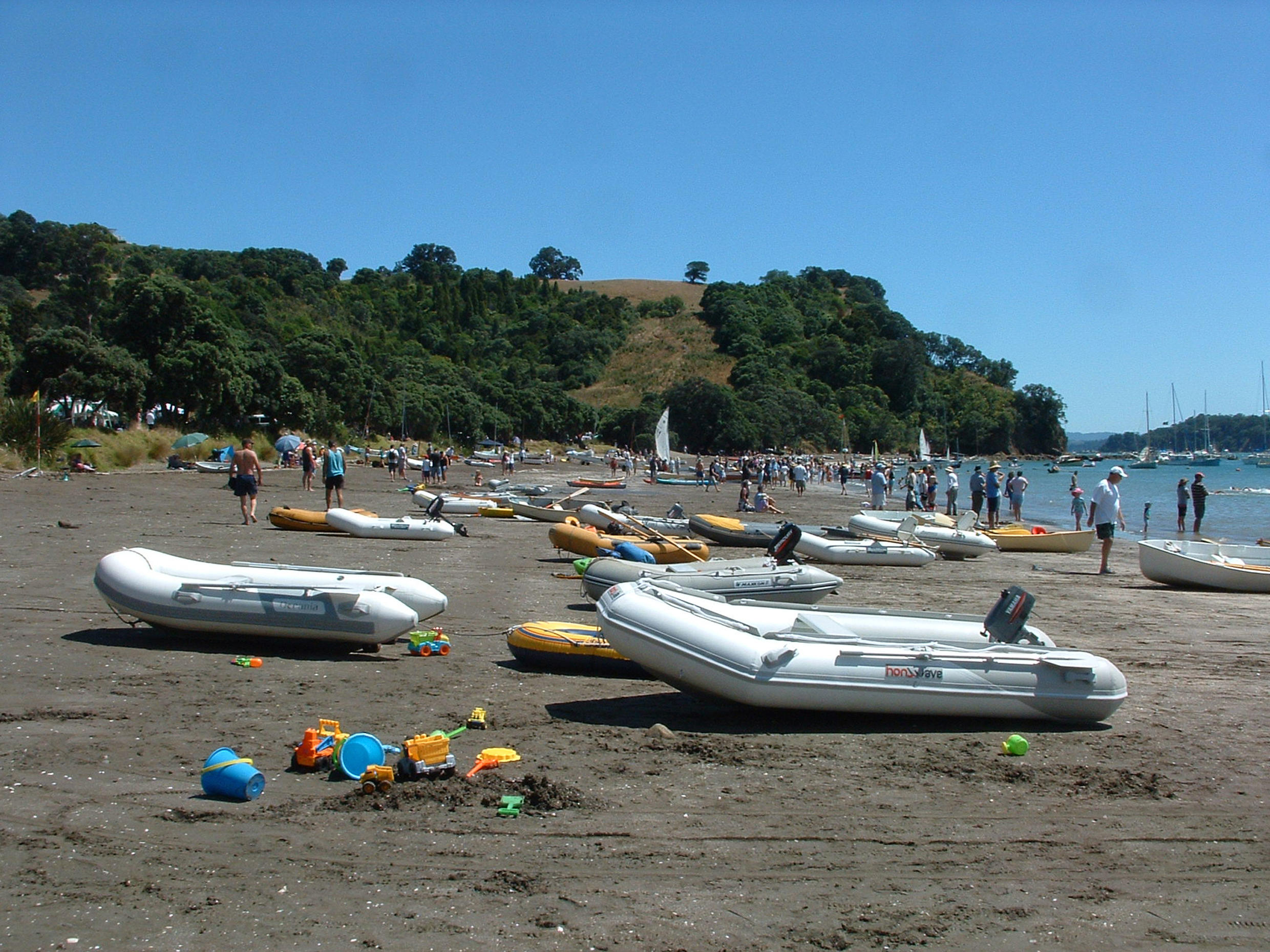 Photograph: People and boats on beach and offshore, Sullivan's Bay ...