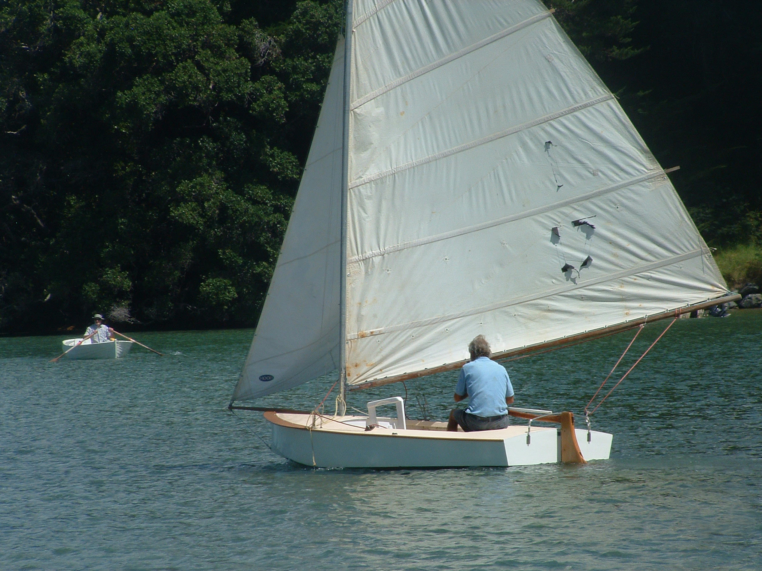 Photograph: Small yacht sailing and a rowing dinghy on the Hauraki Gulf ...