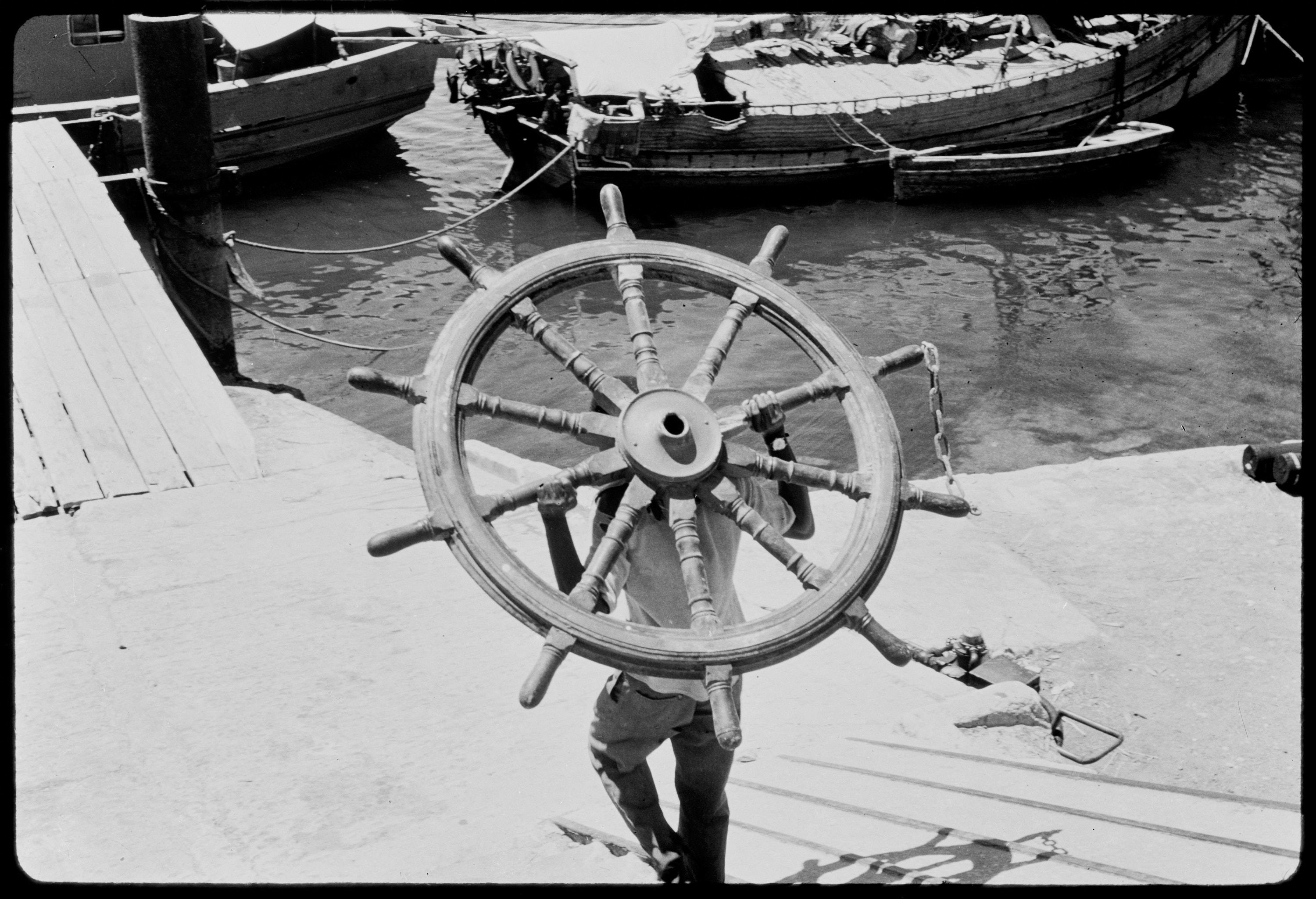 Negative: Man carrying wooden wheel from dhow, Mombasa, 1972 - New ...